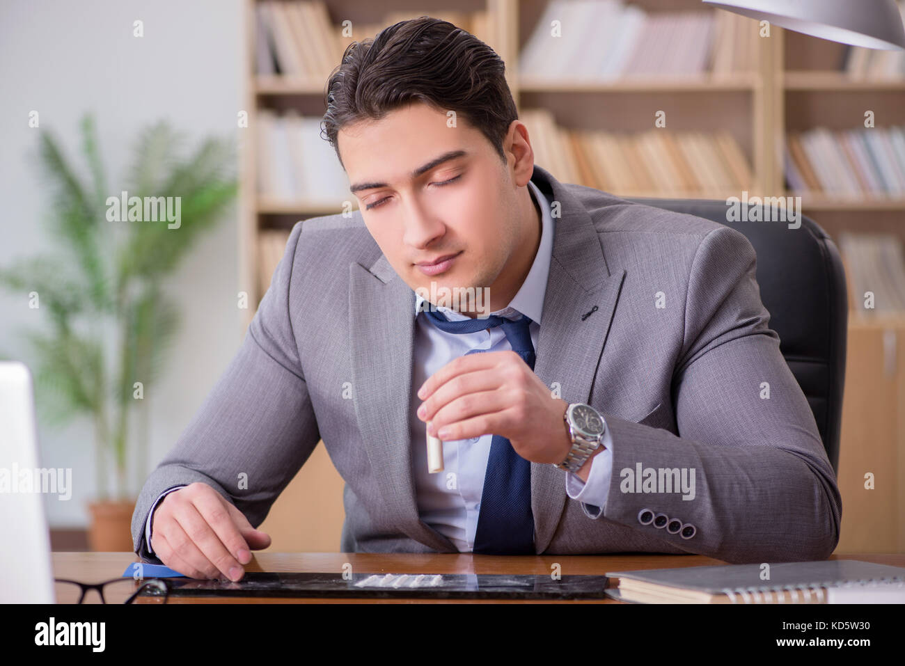 Drug addict businessman in the office Stock Photo - Alamy