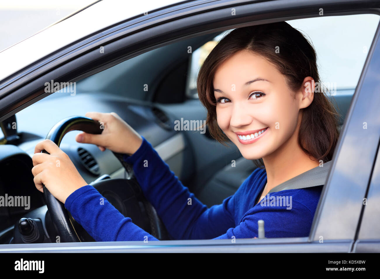 Beautiful woman driver smiling to you from her car Stock Photo - Alamy