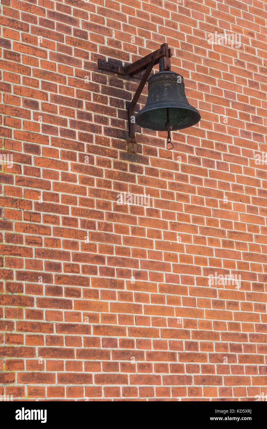 Metal bell on the red brick wall Stock Photo - Alamy