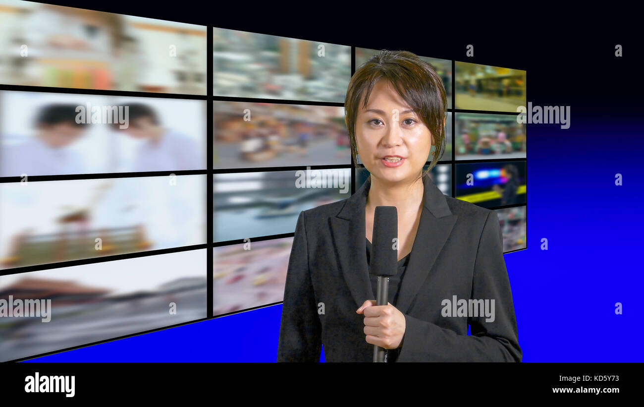 Asian American female news anchor in studio with screens in background ...