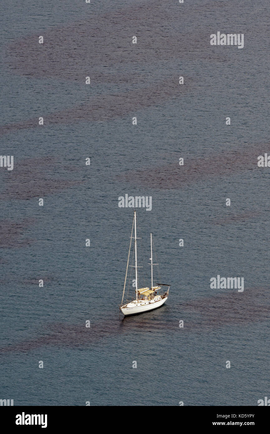 a luxury two masted ketch or large yacht anchored in a beautiful bay in ...