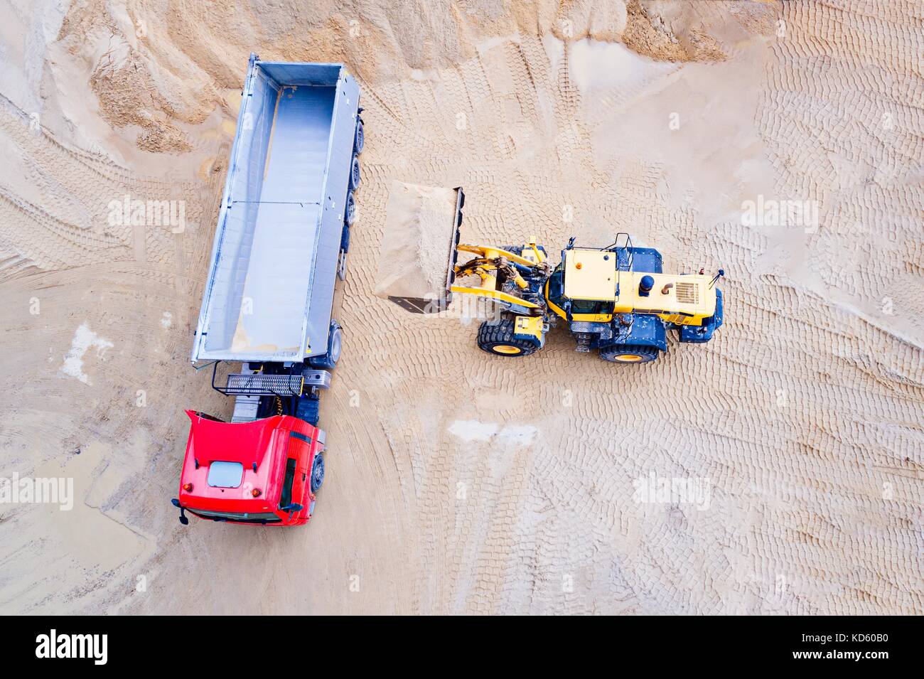 Yellow wheel loader loading sand on dumper truck. Sand quarry Stock ...