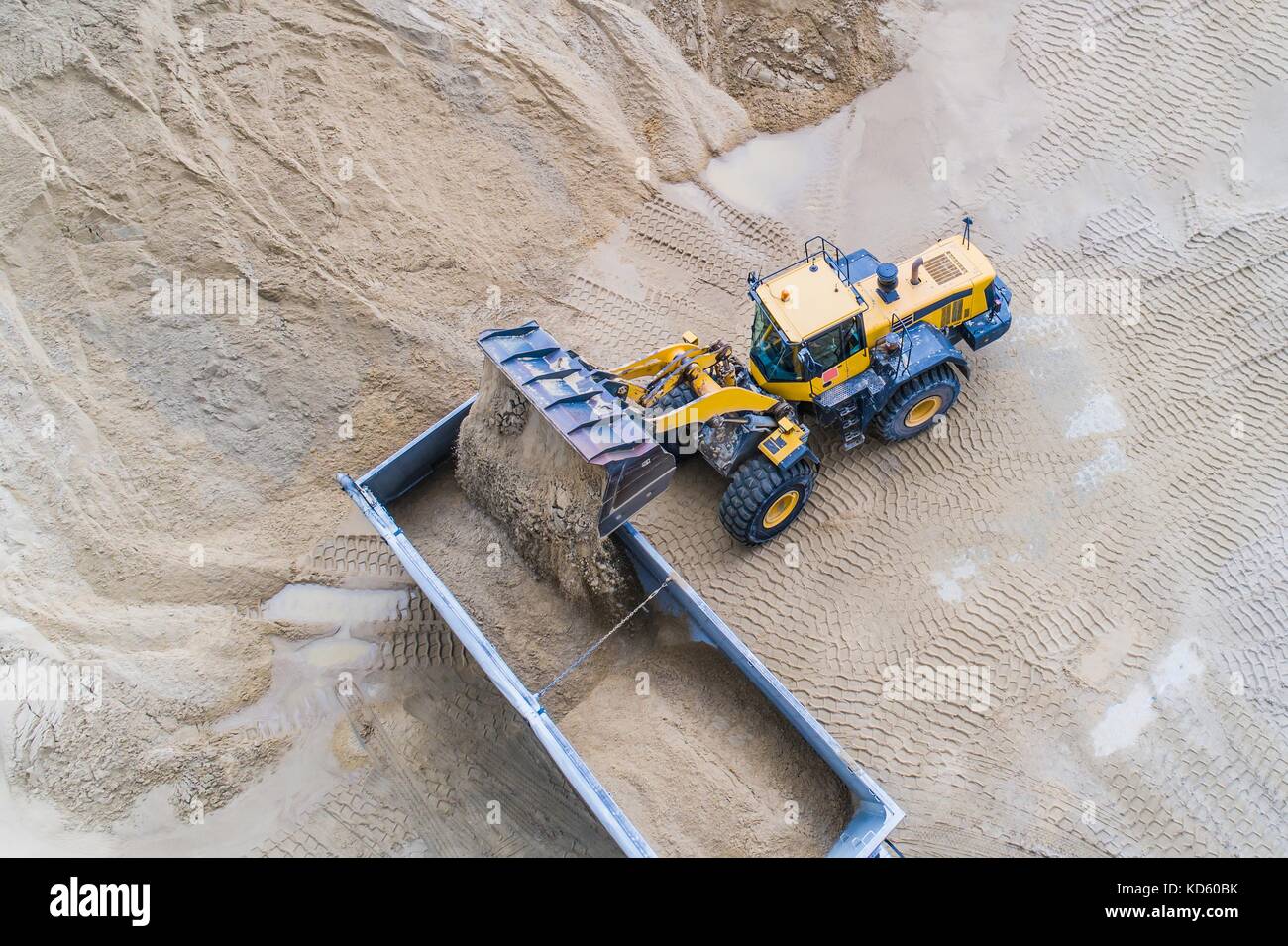 Yellow wheel loader loading sand on dumper truck. Sand quarry Stock ...