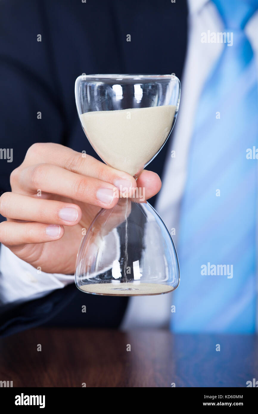 Close-up Of Businessman's Hand Holding A Hourglass Stock Photo - Alamy