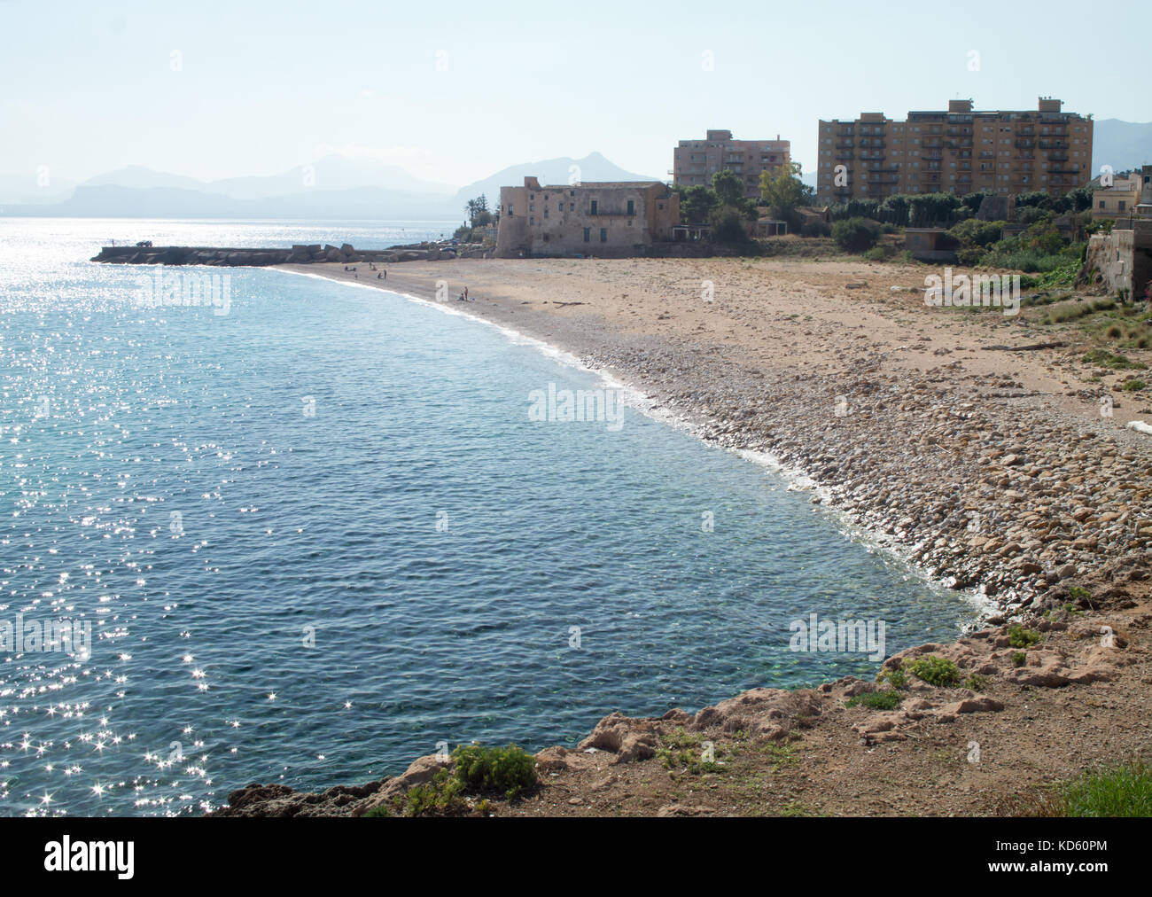 Beach with pier and fishermen seen from afar Stock Photo - Alamy