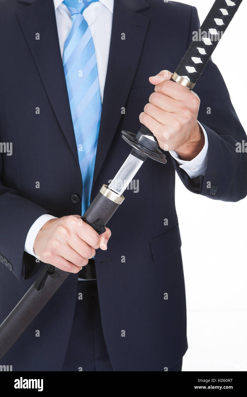 Close-up Of Businessman Removing Sword Over White Background Stock ...