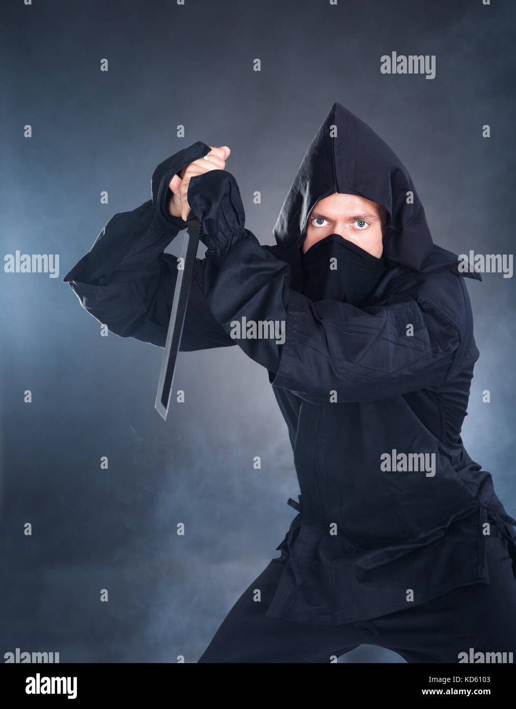 Portrait Of Male Ninja In Black Costume Holding Sword Stock Photo - Alamy