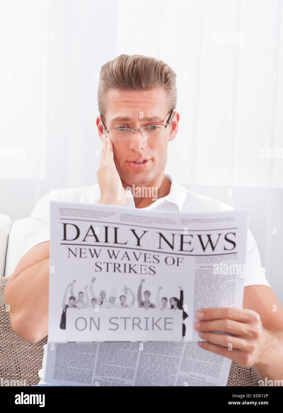 Man Reading Newspaper With The Headline Strike Stock Photo - Alamy