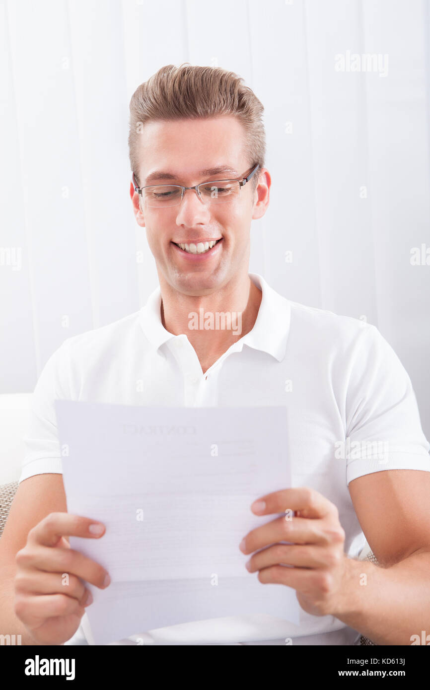 Happy Young Man Reading Paper Holding In Hands Stock Photo - Alamy