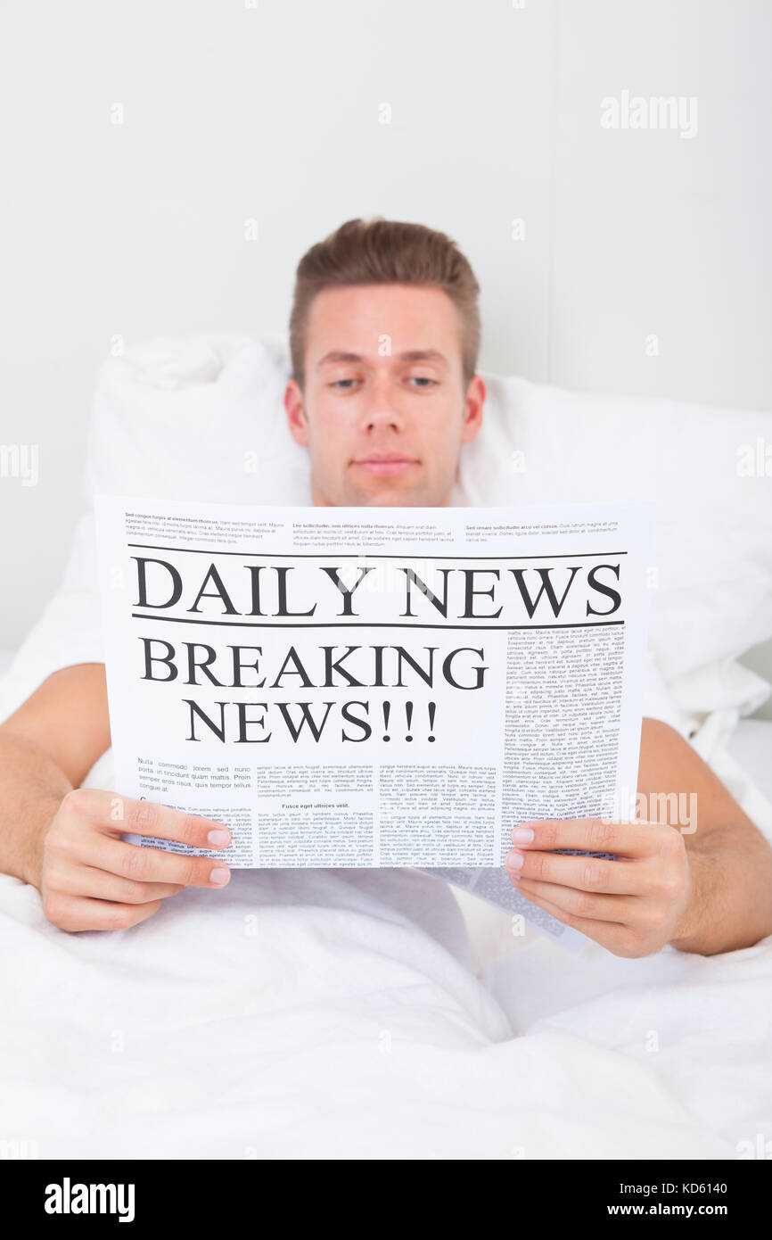Young Man Reading Breaking News On Newspaper Stock Photo - Alamy