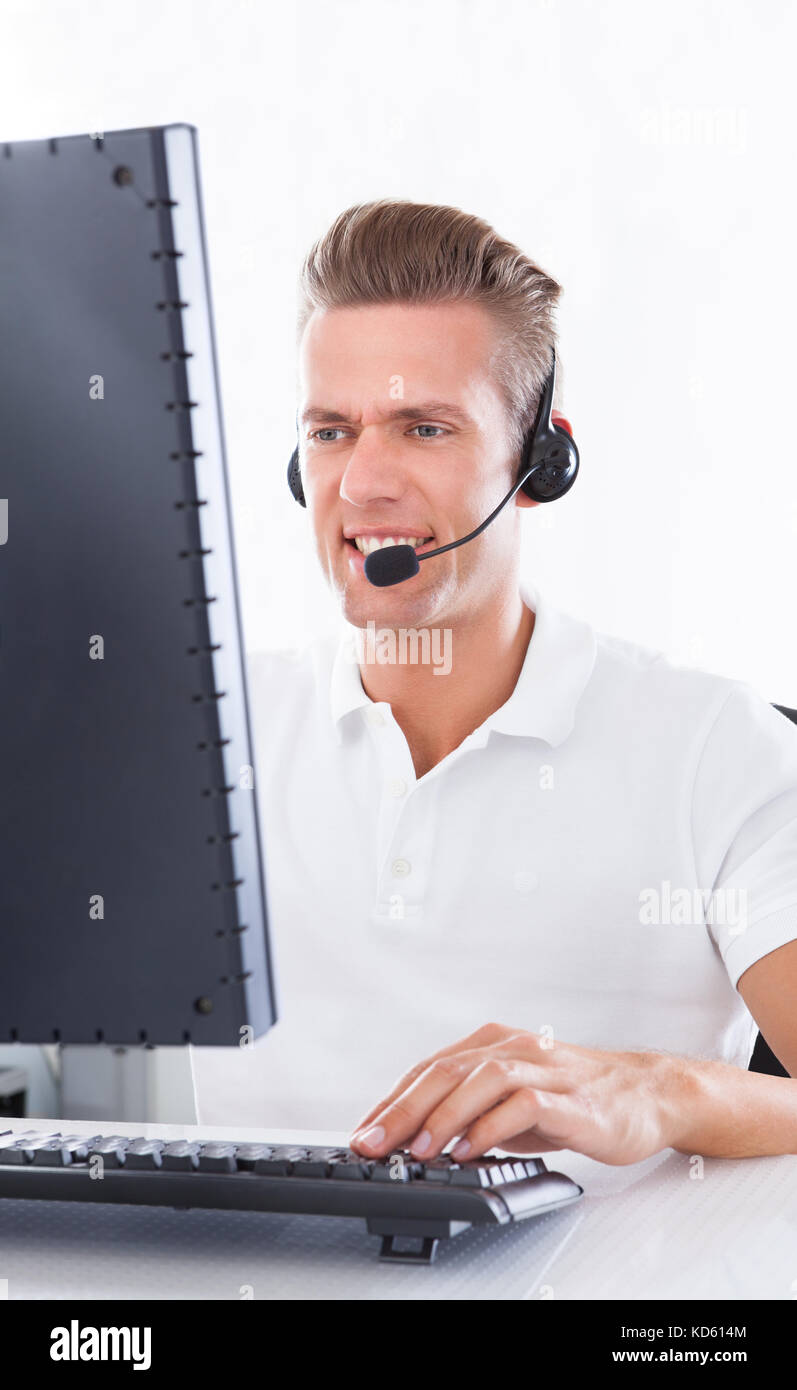 Photo Of Young Man With Headset Using Computer Stock Photo - Alamy