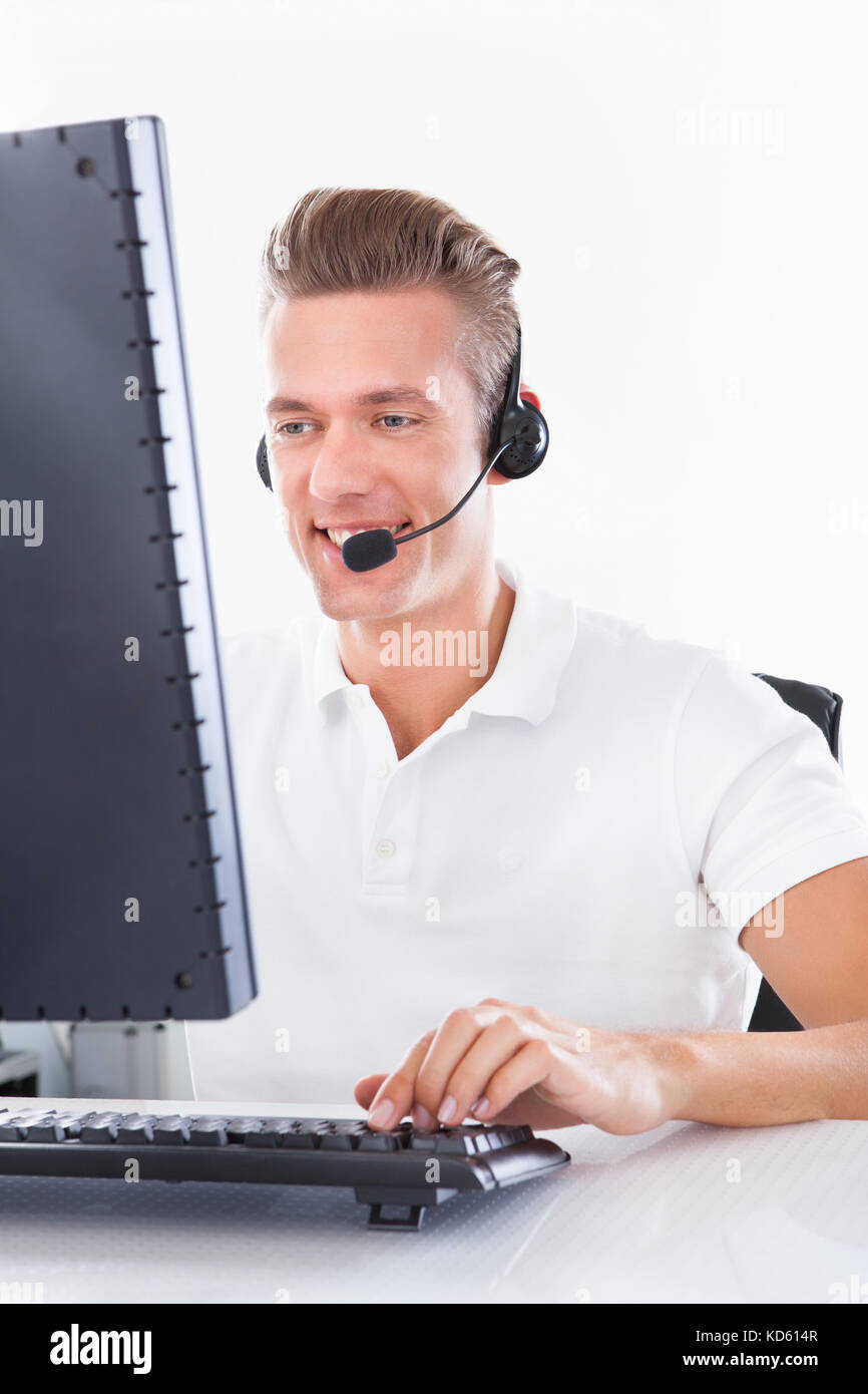 Photo Of Young Man With Headset Using Computer Stock Photo - Alamy