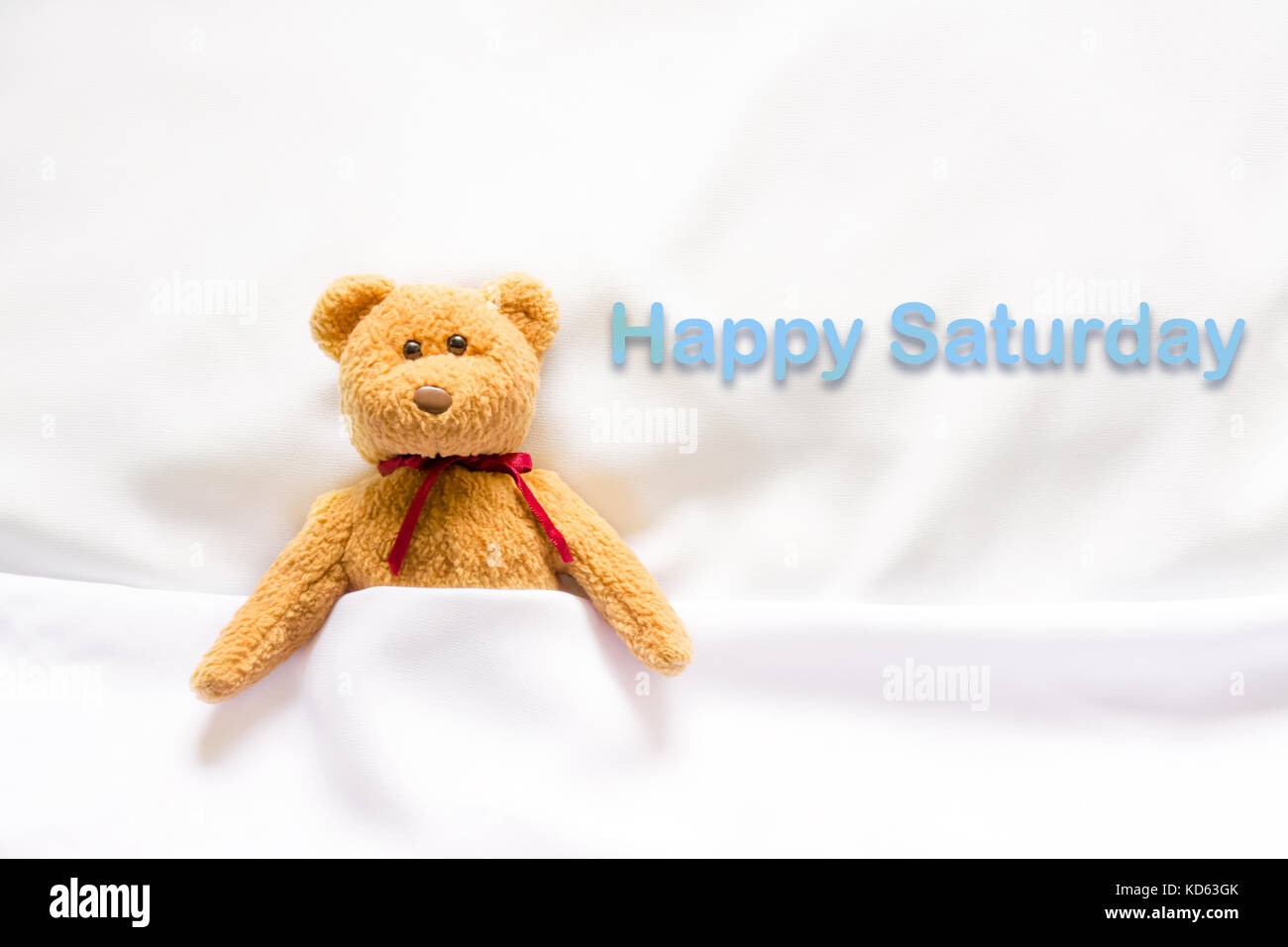 Teddy Bear lying in the white bed with message " Happy Saturday Stock ...