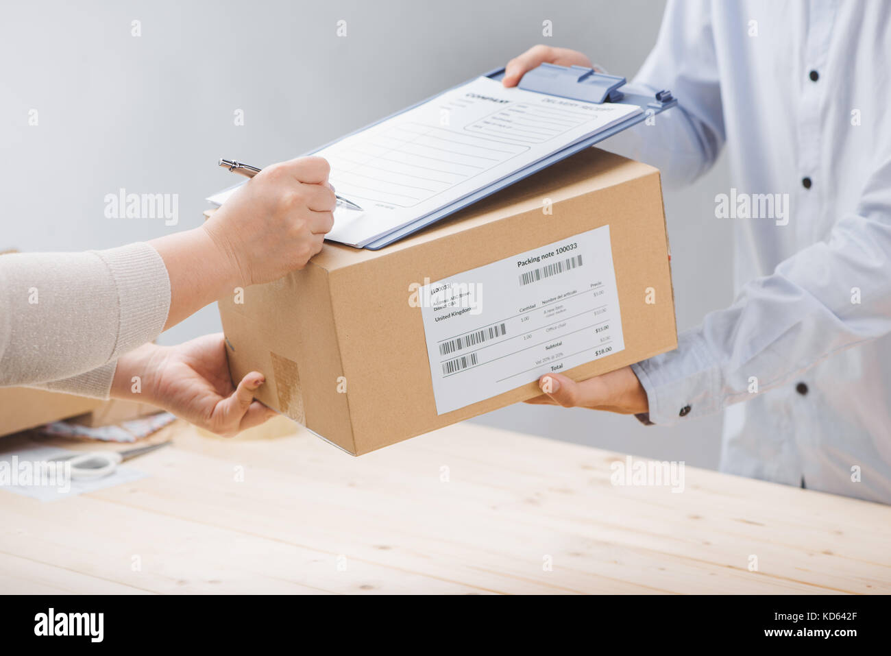 Woman signing receipt of delivery package, close up Stock Photo - Alamy