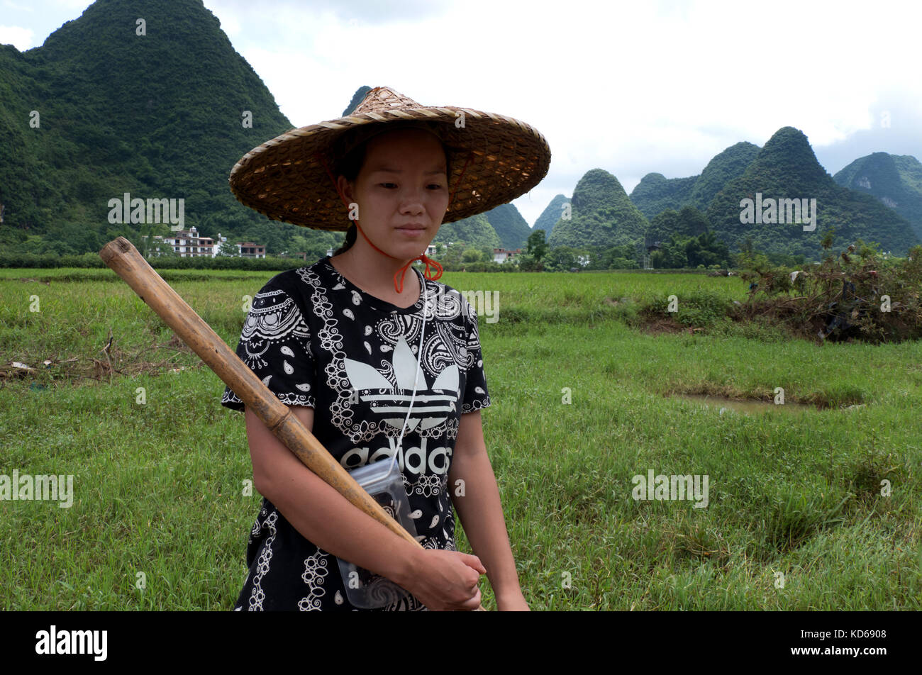 Portrait of young Chinese woman working as peasant in paddy field in ...