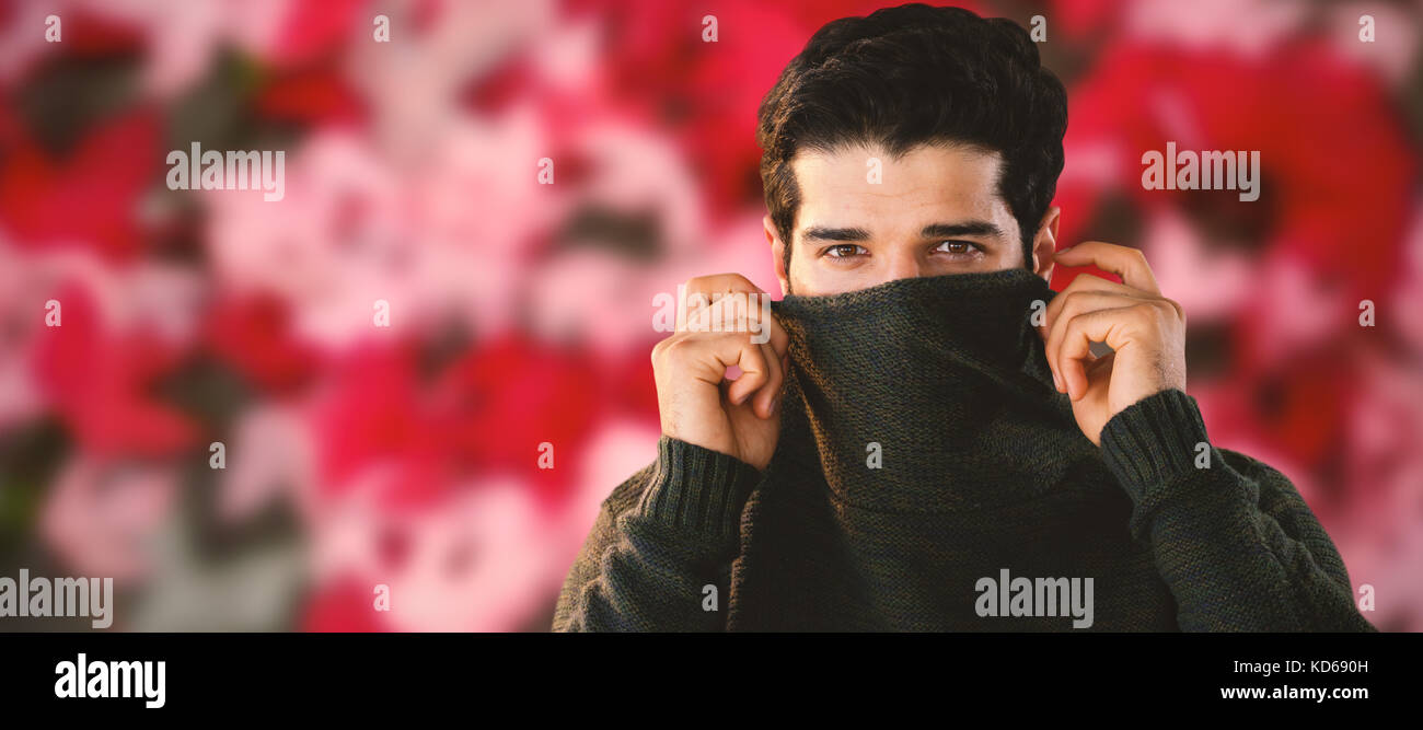 Portrait of man hiding face with sweater against maple leaves fallen on ...