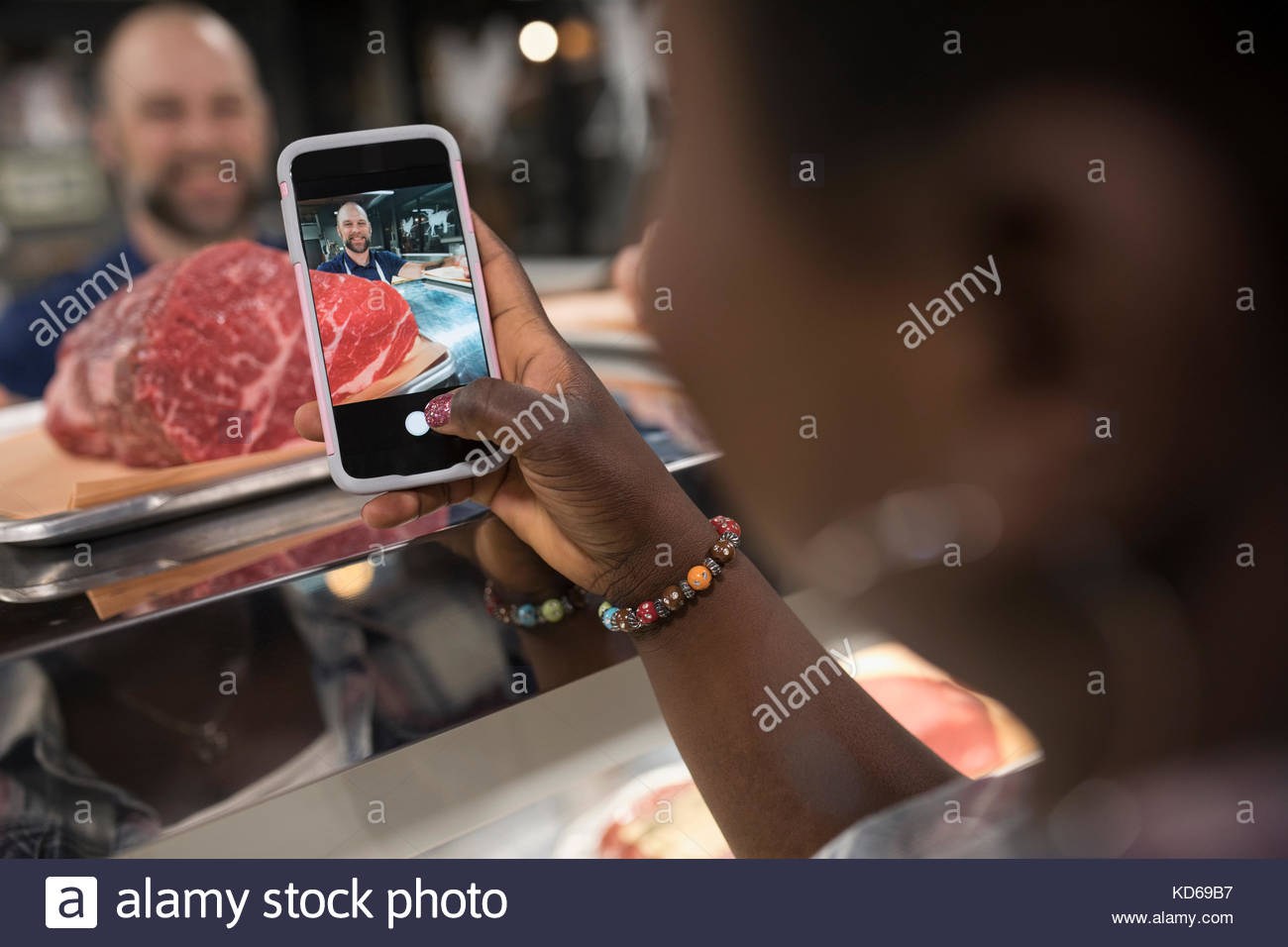 Customer with camera phone photographing raw red meat in butcher Stock ...