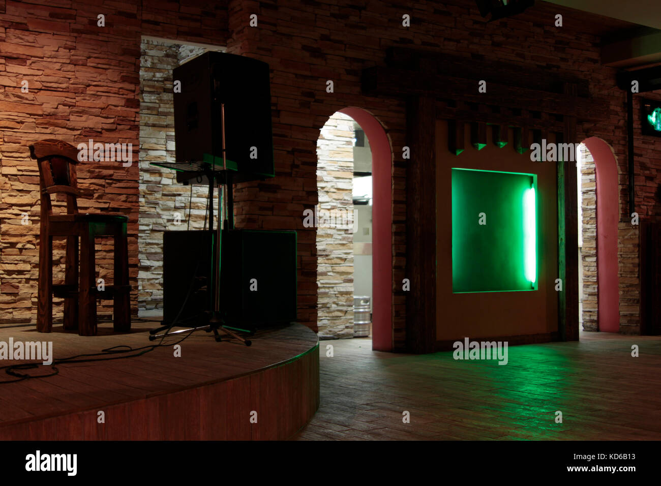 Stage with speaker in cafe with green illuminated niche Stock Photo - Alamy