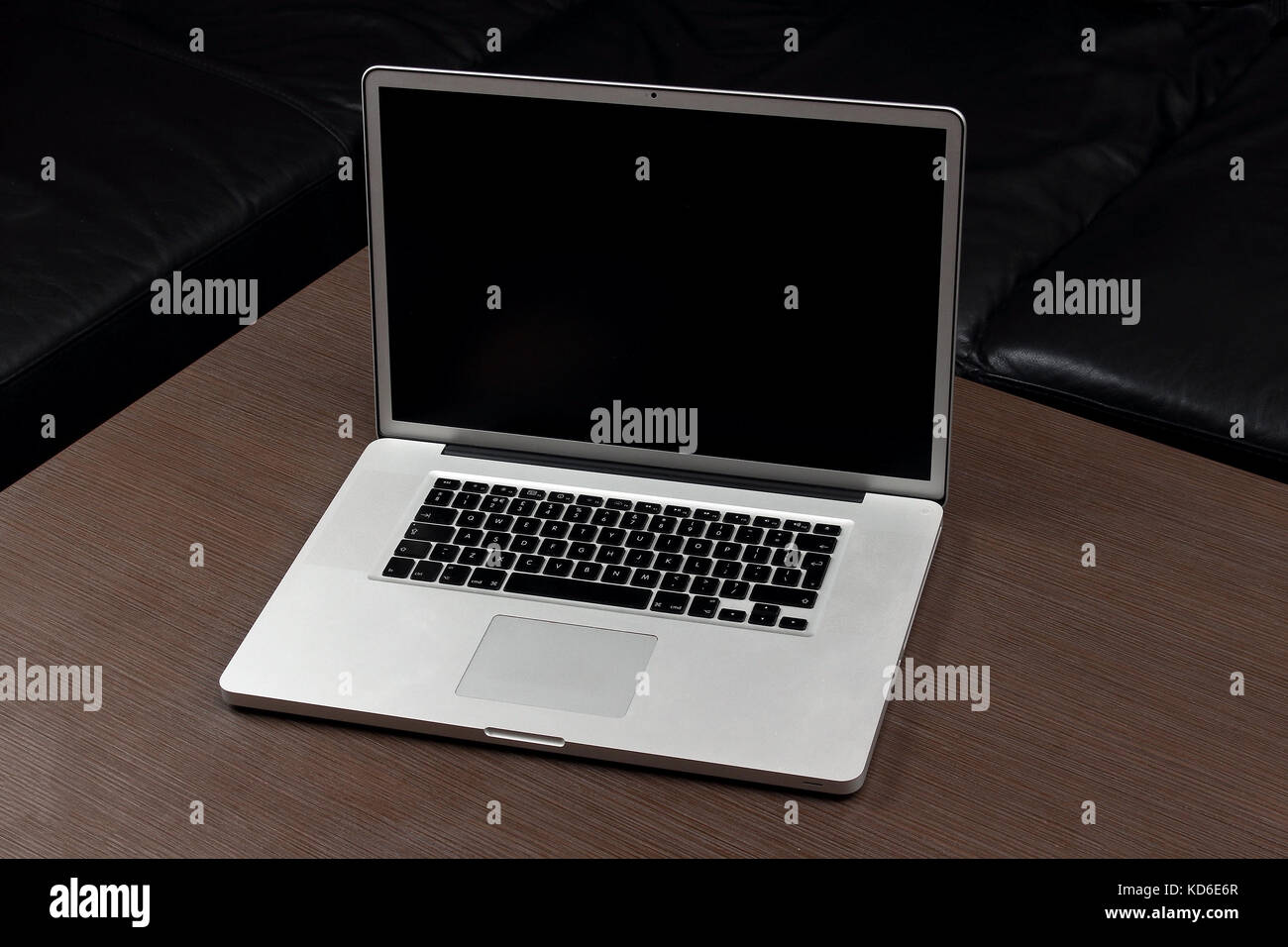 Modern laptop with black empty screen open on wooden table Stock Photo ...