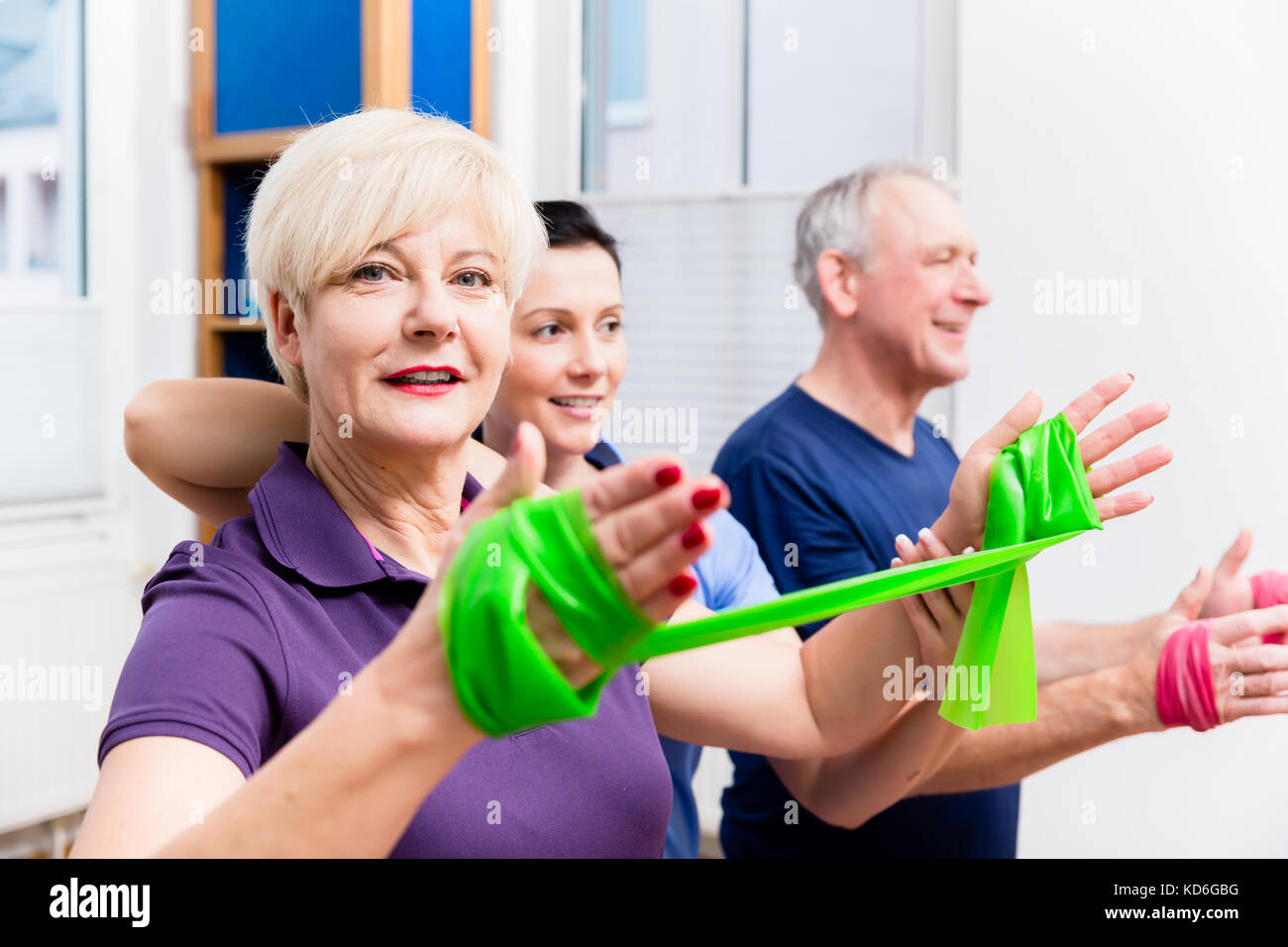 Physio showing senior couple how to use rubber band as expander Stock ...