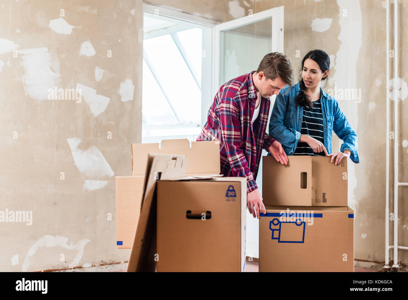 Young couple opening boxes during renovation of new home after m Stock ...