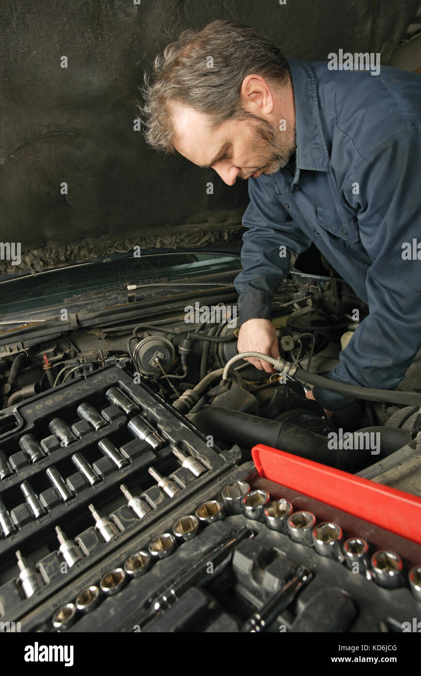 Photo of a mechanic repairing an engine of an old car Stock Photo - Alamy