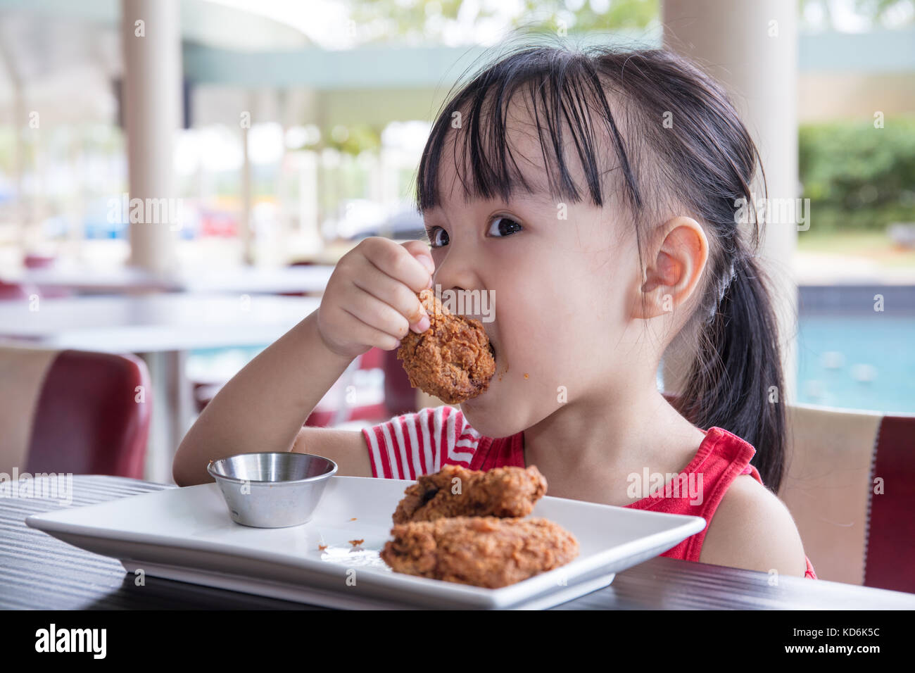 Asian Little Chinese Girl Eating Fried chicken at Outdoor Cafe Stock ...