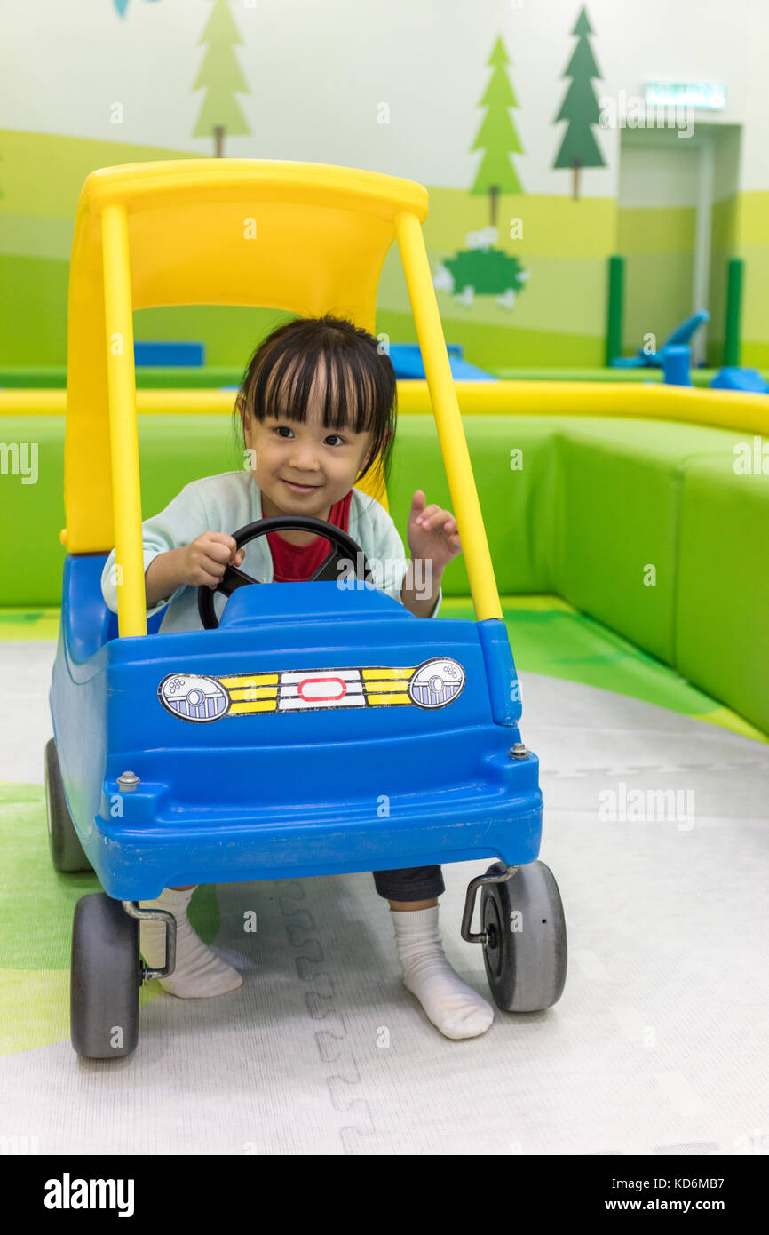 Asian Chinese little girl driving toy car at indoor playground Stock ...