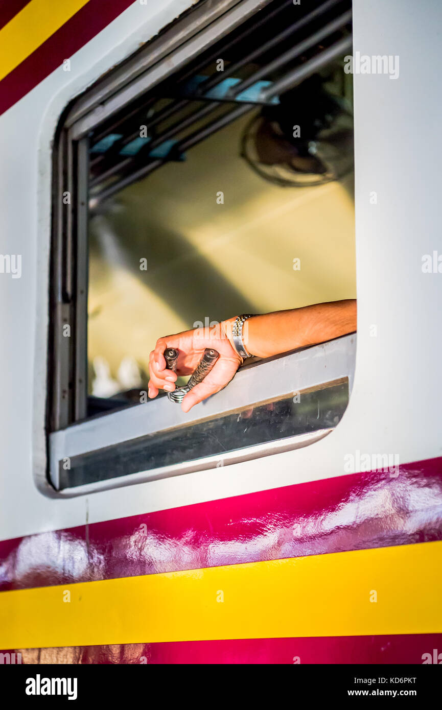 A train passenger exercises his hand whilst waiting in the train ...