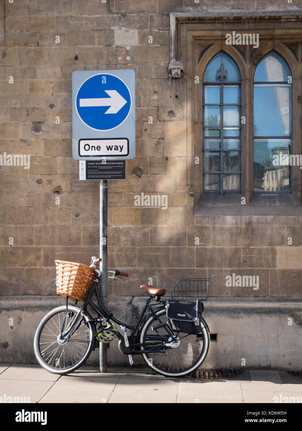 A traditional bicycle with a basket leaning against a wall in sunshine ...