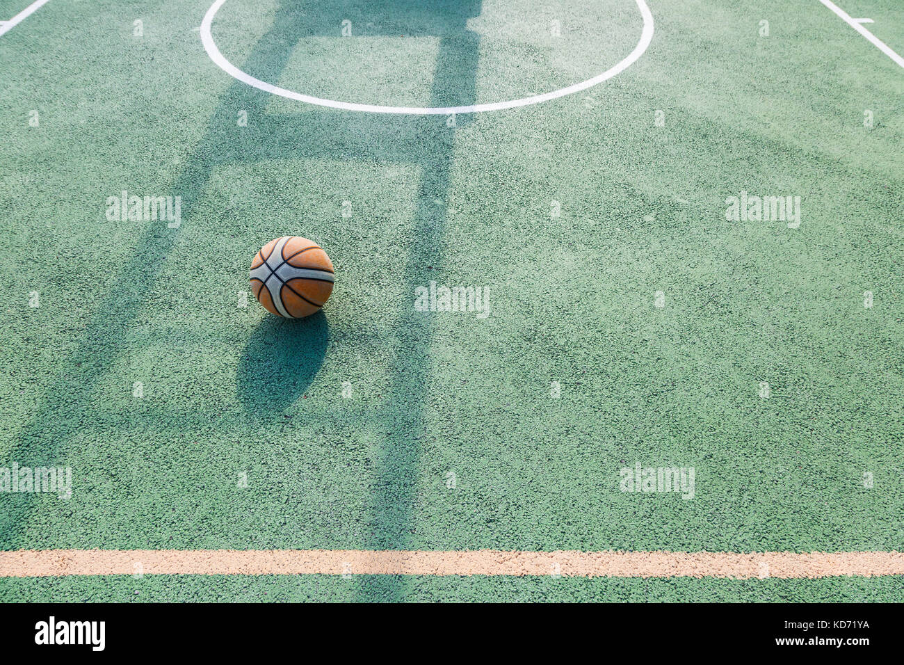 old used basketball being left on an outdoor basketball court on a ...