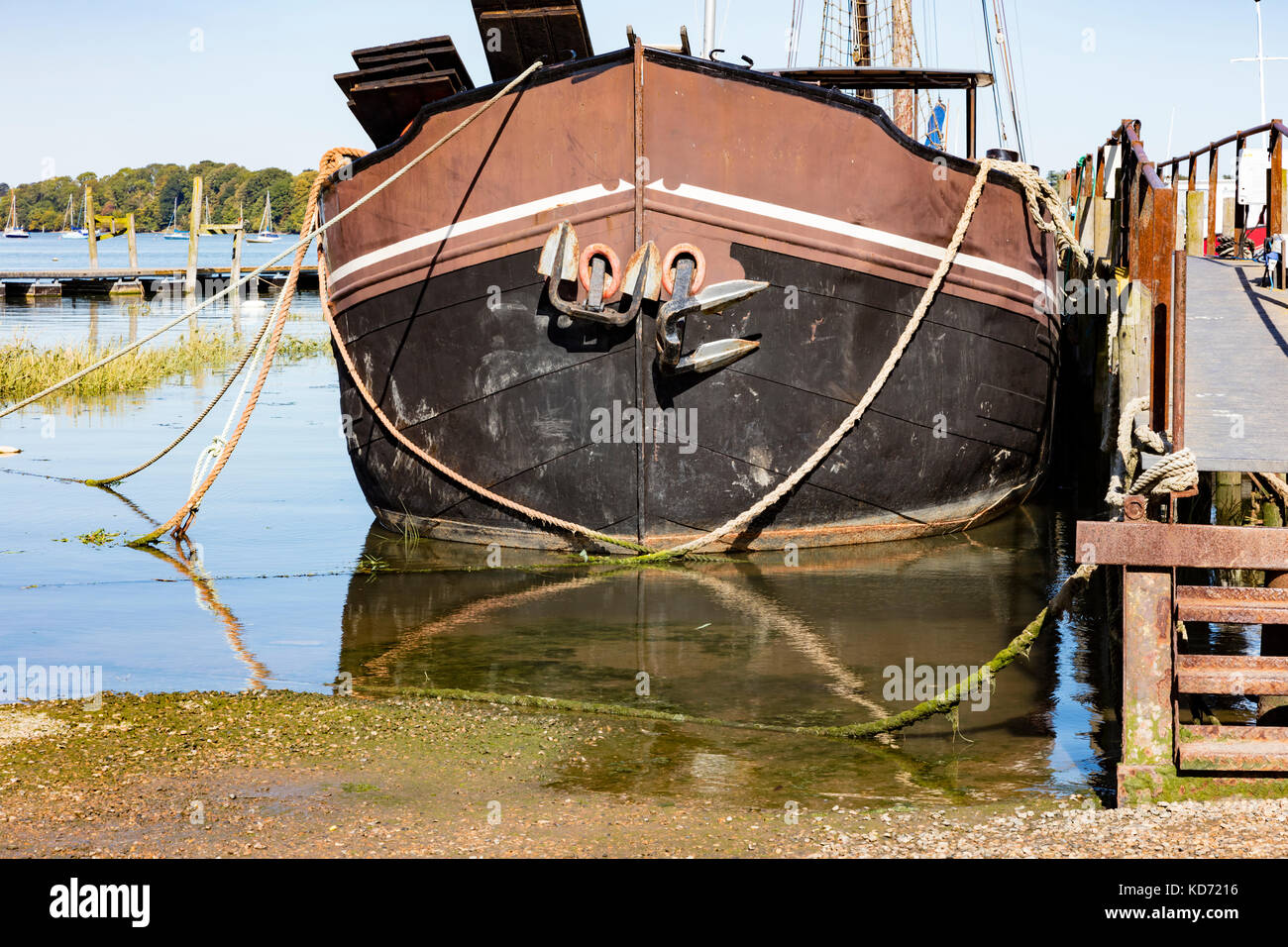 A moored barges bow and its mooring ropes make curved patterns in the ...
