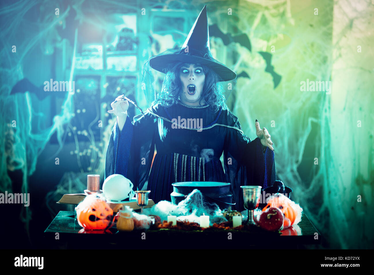 Witch with awfully face and hat on her head in creepy surroundings full ...