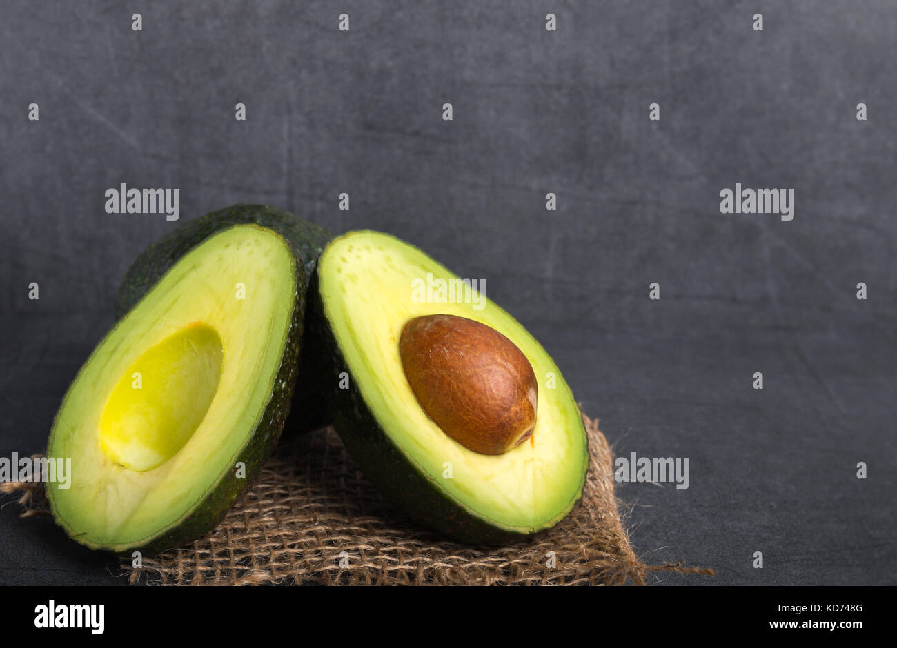 avocado cut in half on stone background Stock Photo - Alamy