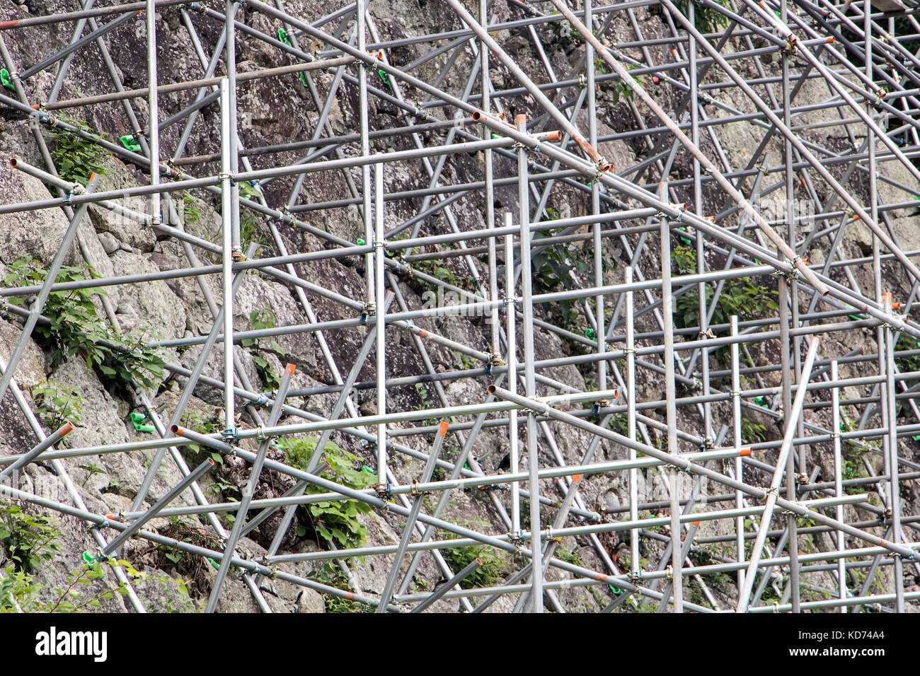 Construction of a stone wall. Steel scaffolding built on the stone ...