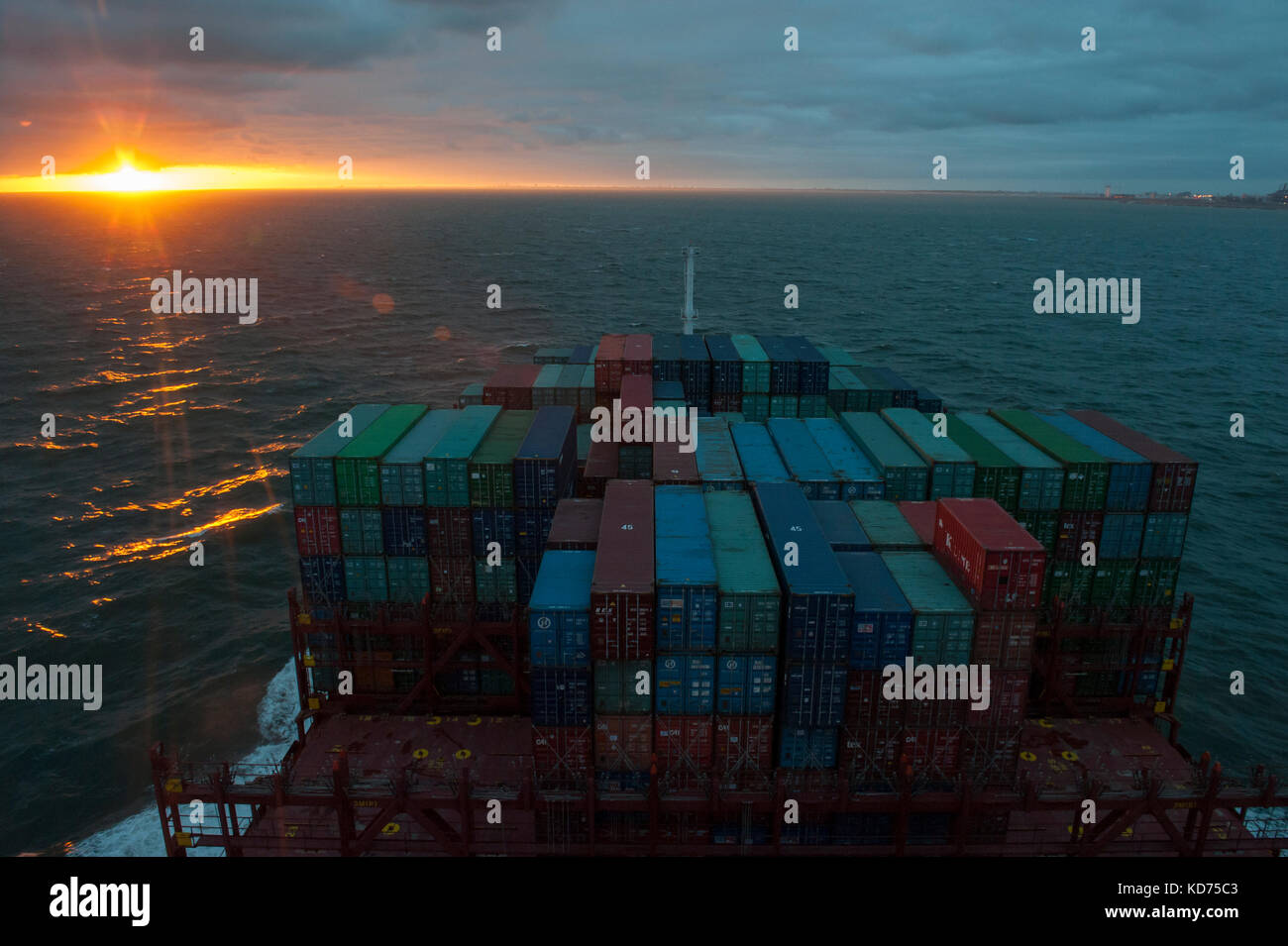 View across the deck of a container ship at sunrise in the North Sea ...