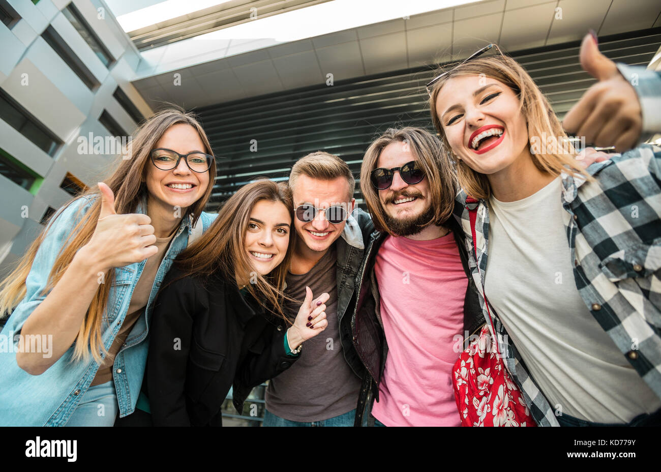 Casual stylish group of happy smiling students before modern building ...