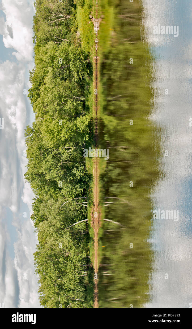 A horizontal shot of a river bank, displayed vertically to emphasize ...