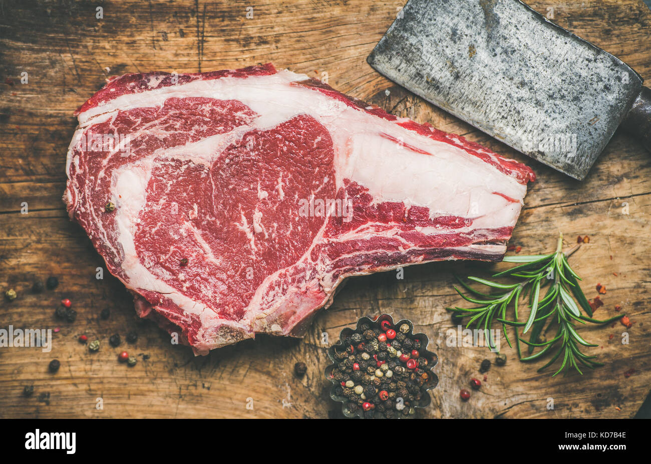 Raw beef steak rib-eye with seasoning and knife, rustic background ...