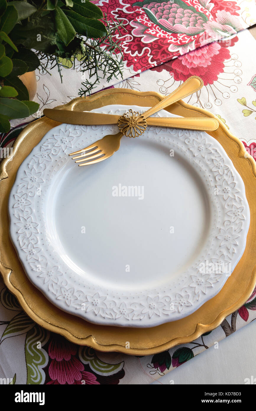 christmas place setting, table ready for lunch, on golden plates and ...