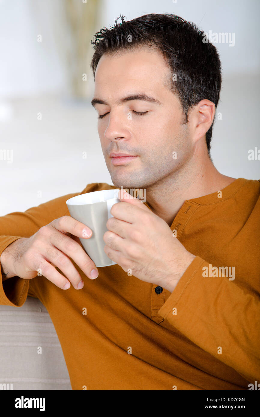 young man enjoying tea with closed eyes Stock Photo - Alamy