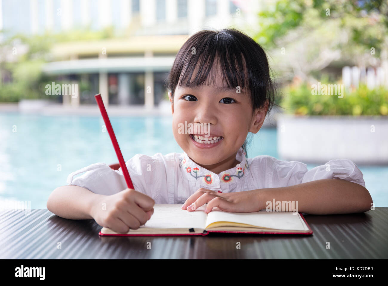 Asian Chinese little girl doing homework at outdoor cafe Stock Photo ...