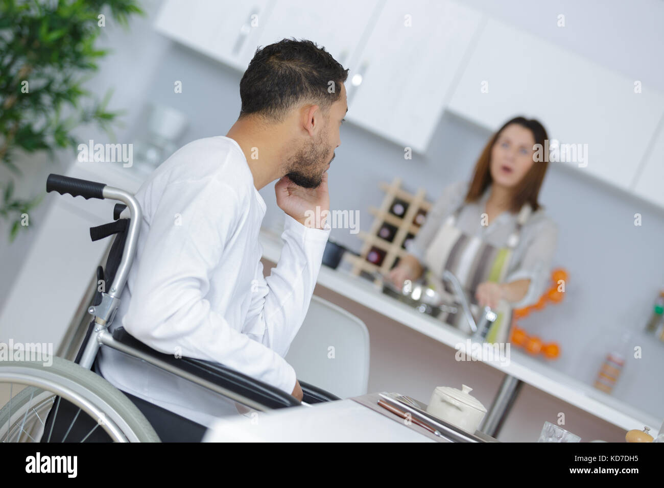 man sitting at the table on a wheelchair Stock Photo - Alamy