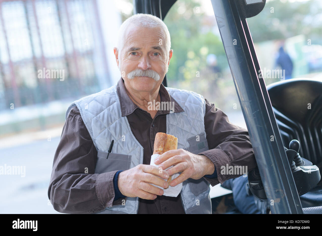 male warehouse worker eating sandwich Stock Photo - Alamy