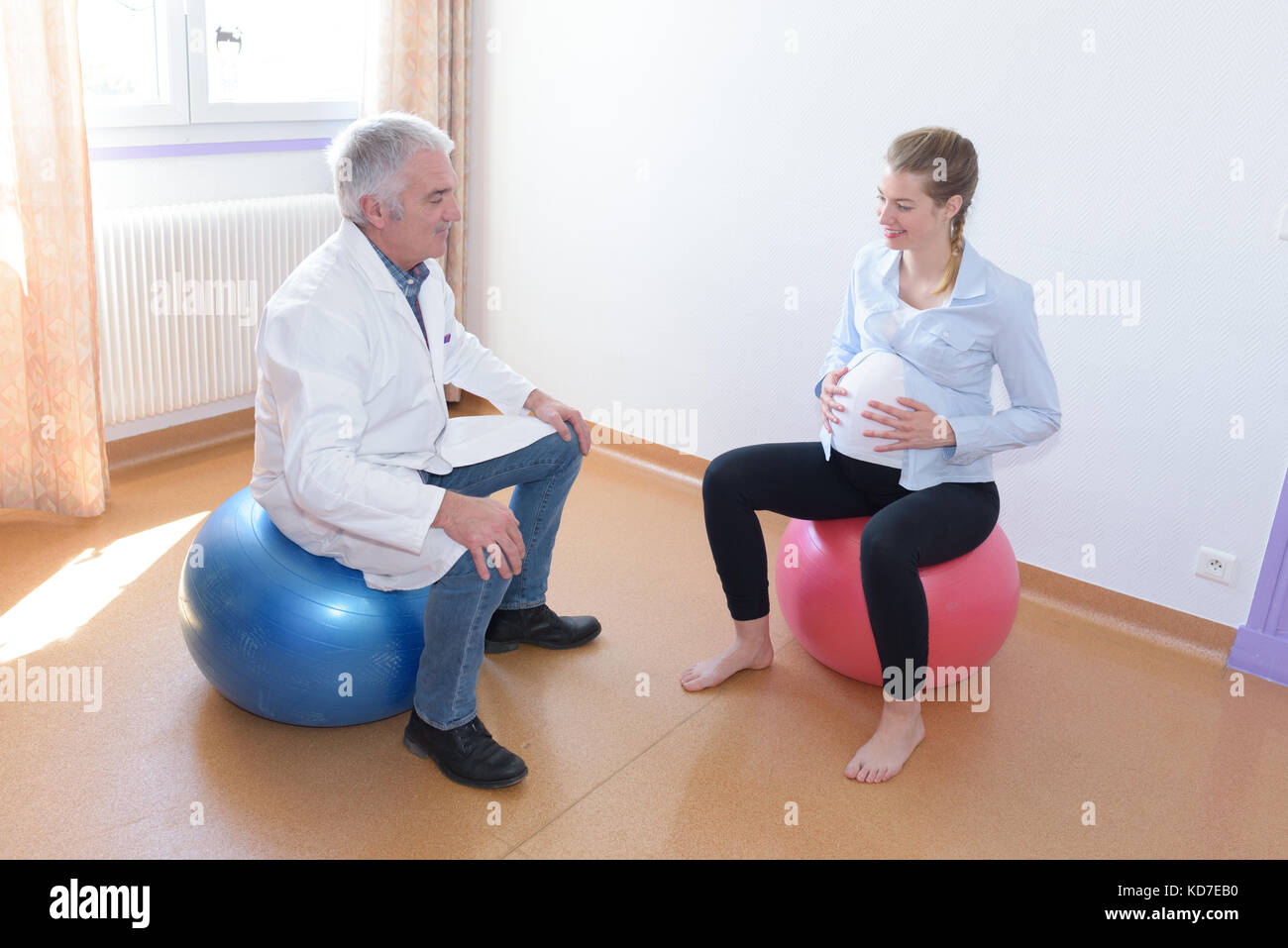 Pregnant lady and doctor sat on aerobics balls Stock Photo - Alamy