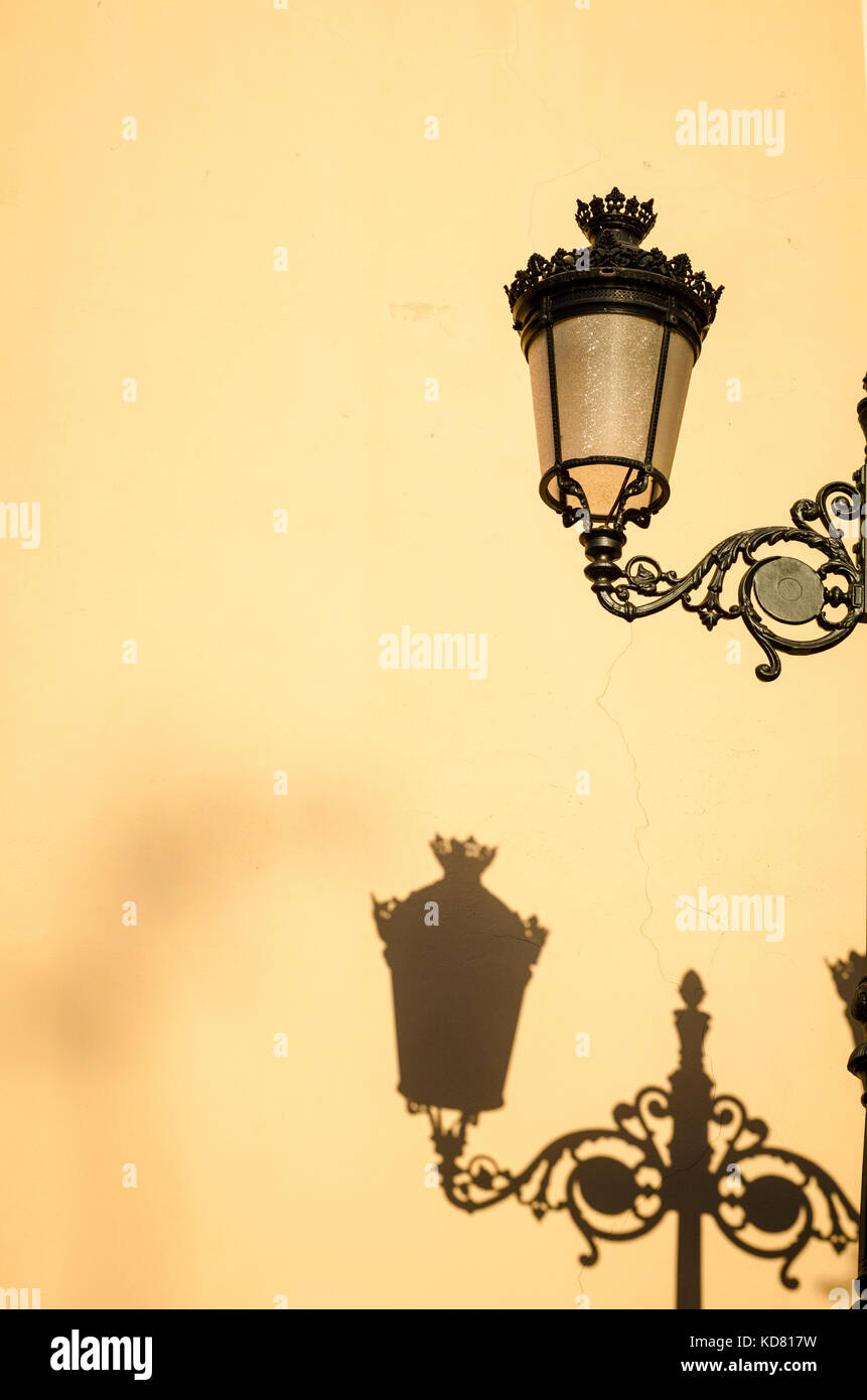 Cast irons street light casting a shadow on a Mediterranean old town ...