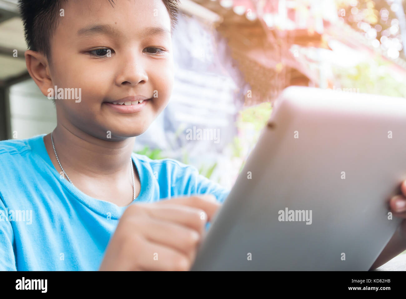 Happy asian boy using tablet and smiling outdoor with sunlight, Child ...