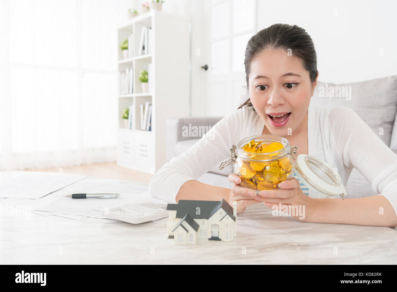 happy young woman holding coin deposit feeling cheerful when she ...