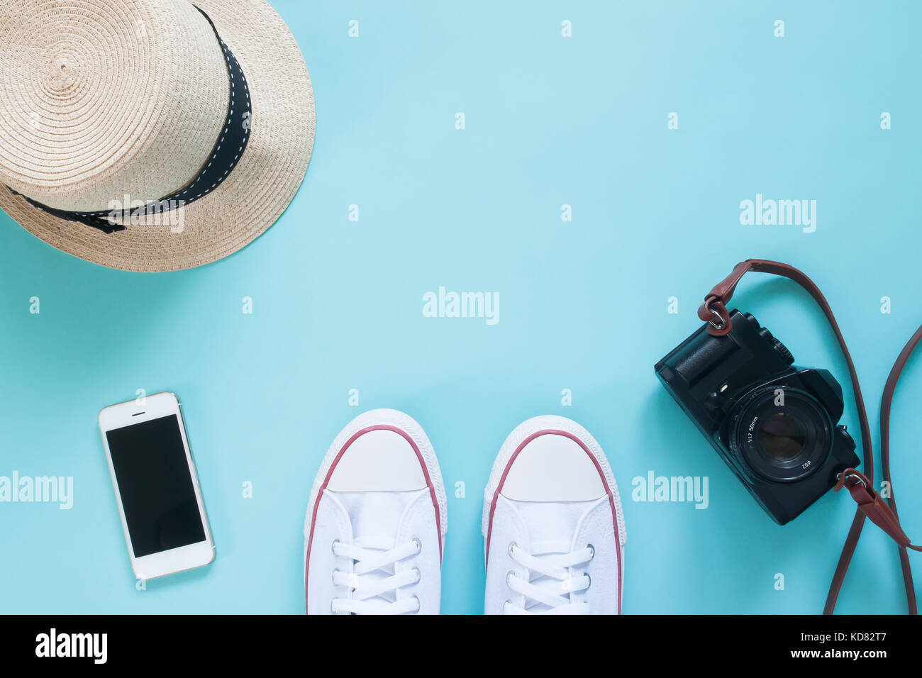 Overhead view of selfie of sneakers with smartphone, camera and hat on ...