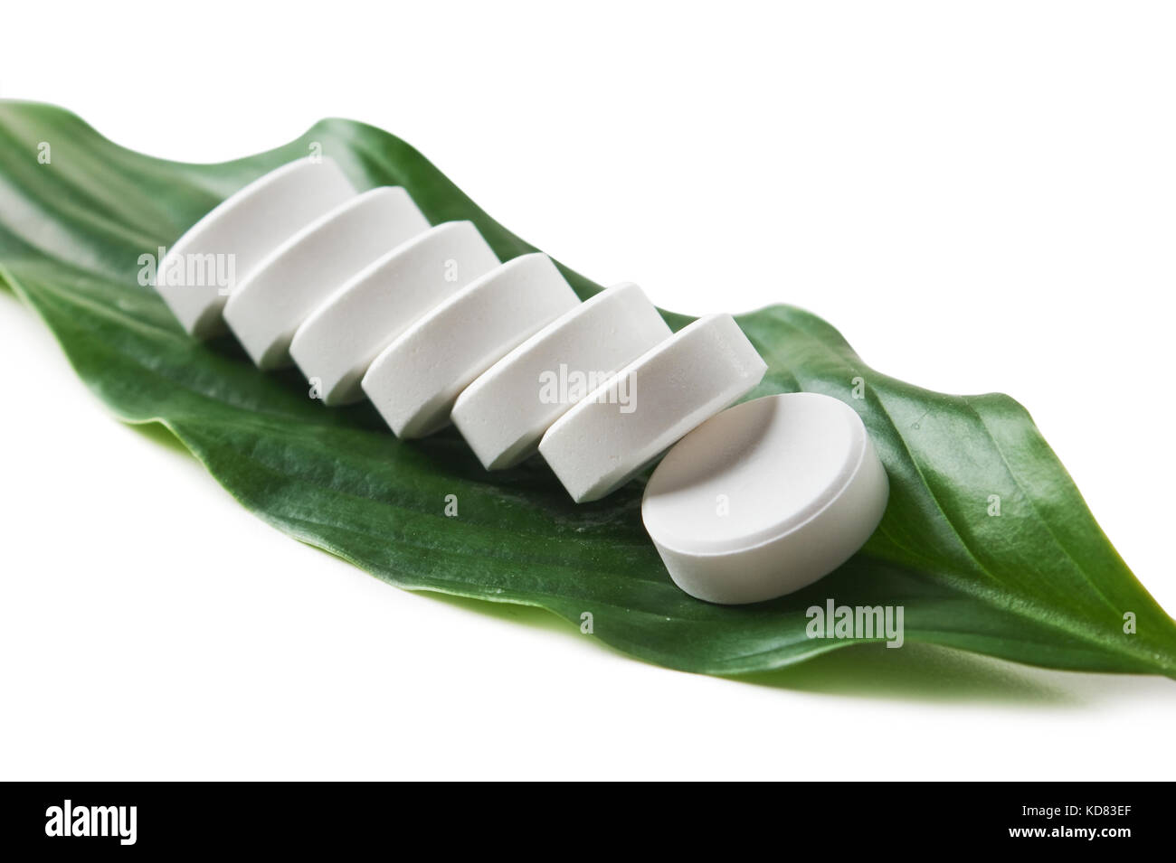 white pill lying on a green leaf isolated on a white background Stock ...